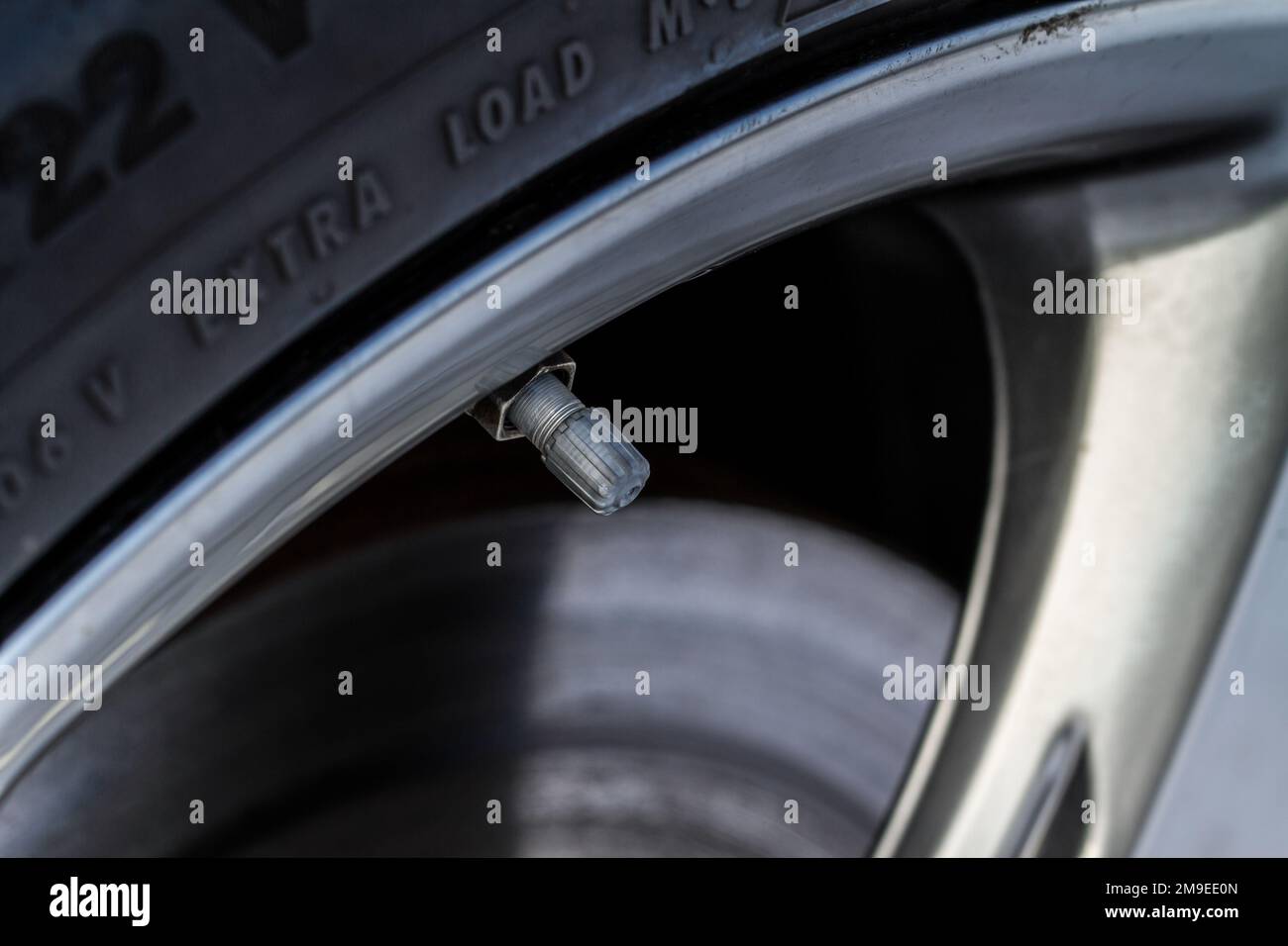 Tire valve cap on modern car wheels. Close up of a new car tire valve ...