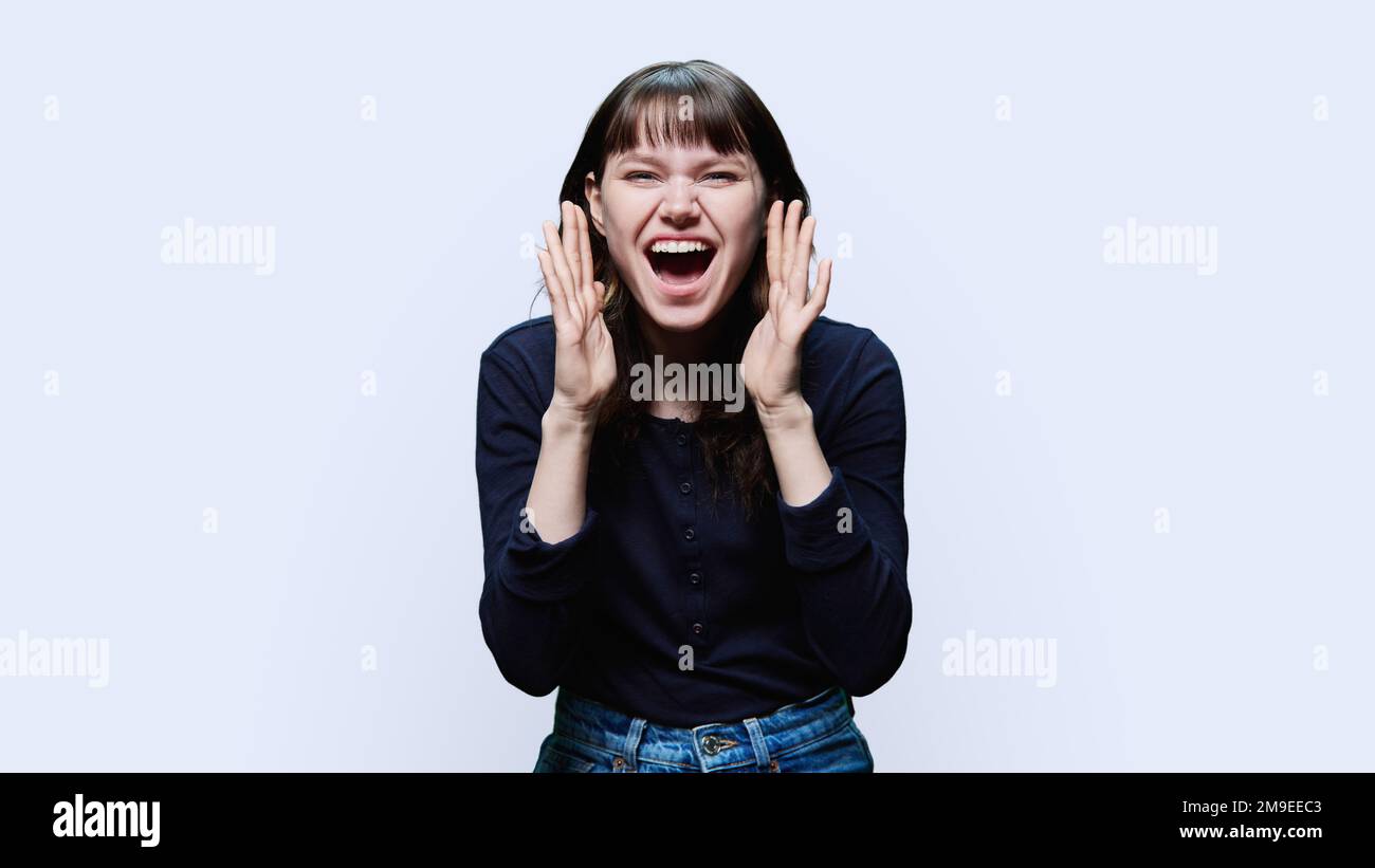 Emotional young female screaming at camera, on light background Stock ...