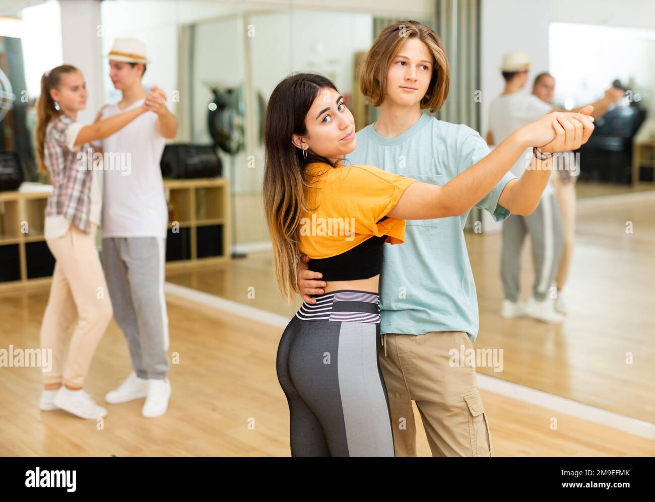 Group of teenage boys and girls training slow foxtrot movements in ...