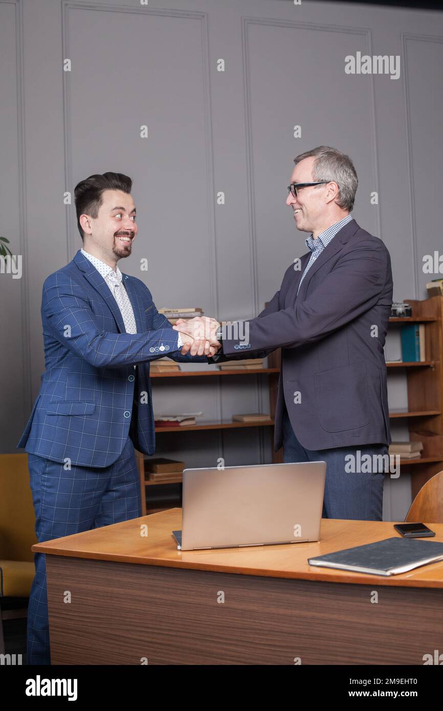 Two business people in blue suits are happy and joyful because of ...