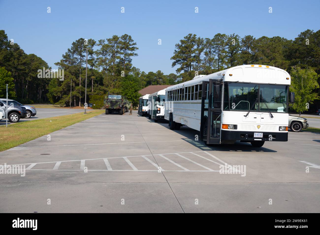 A U.S. Marine Corps 7-ton and shuttle buses are staged at a rally point ...