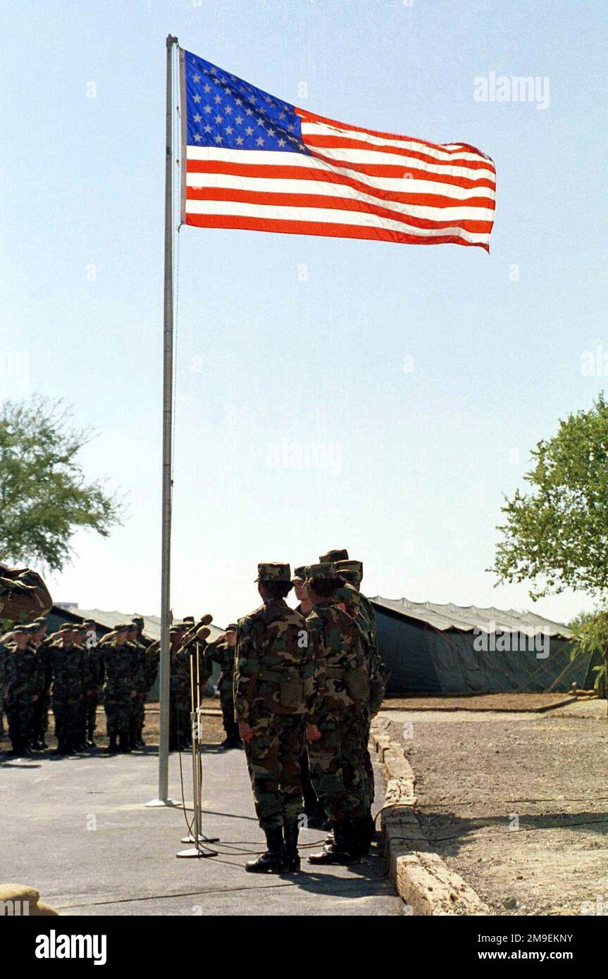 Medium long shot, USAF personnel salute U.S. Flag during "Warrior Week ...