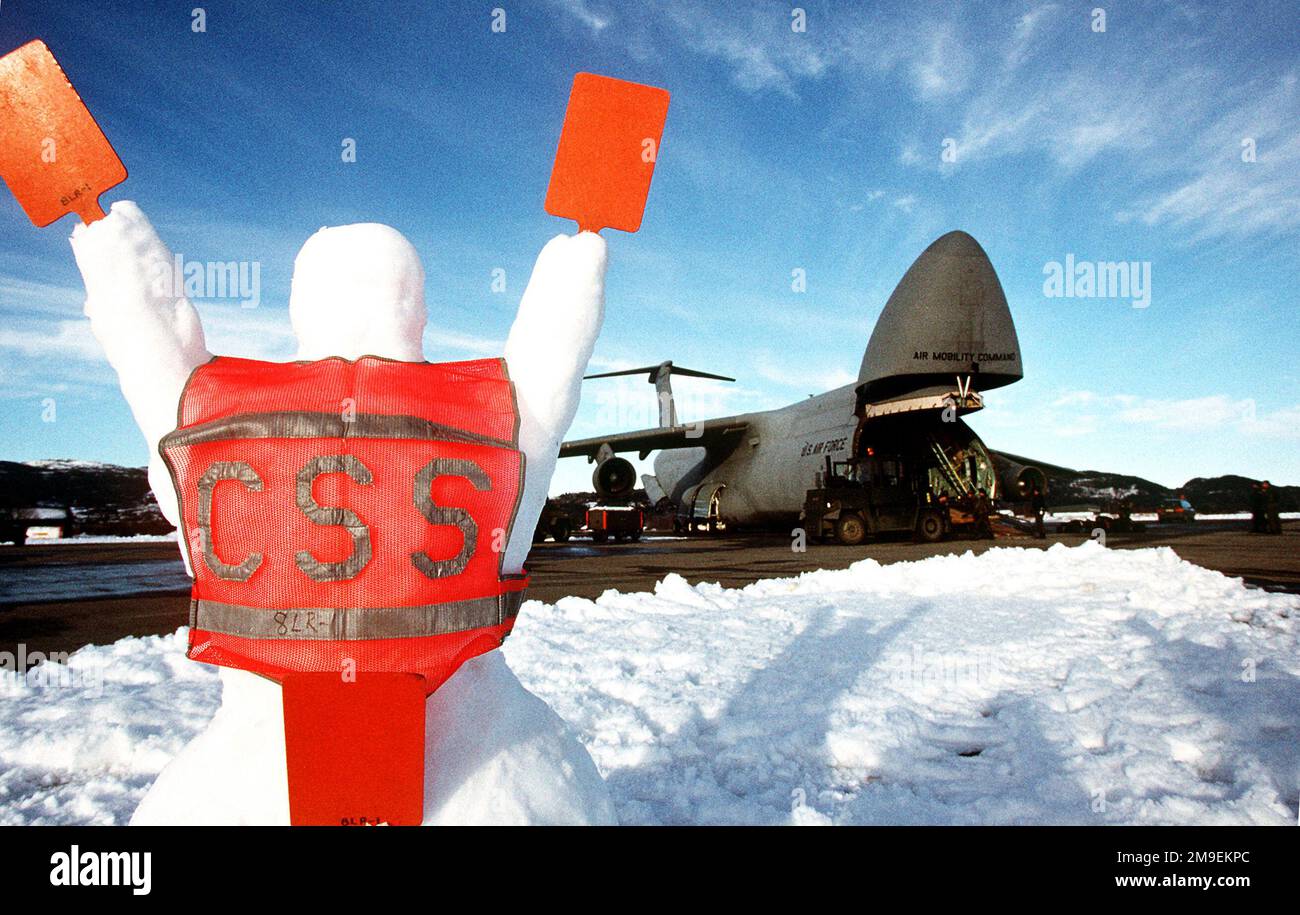 A snowman signals as he marshalls aircraft at the end of the ramp in ...