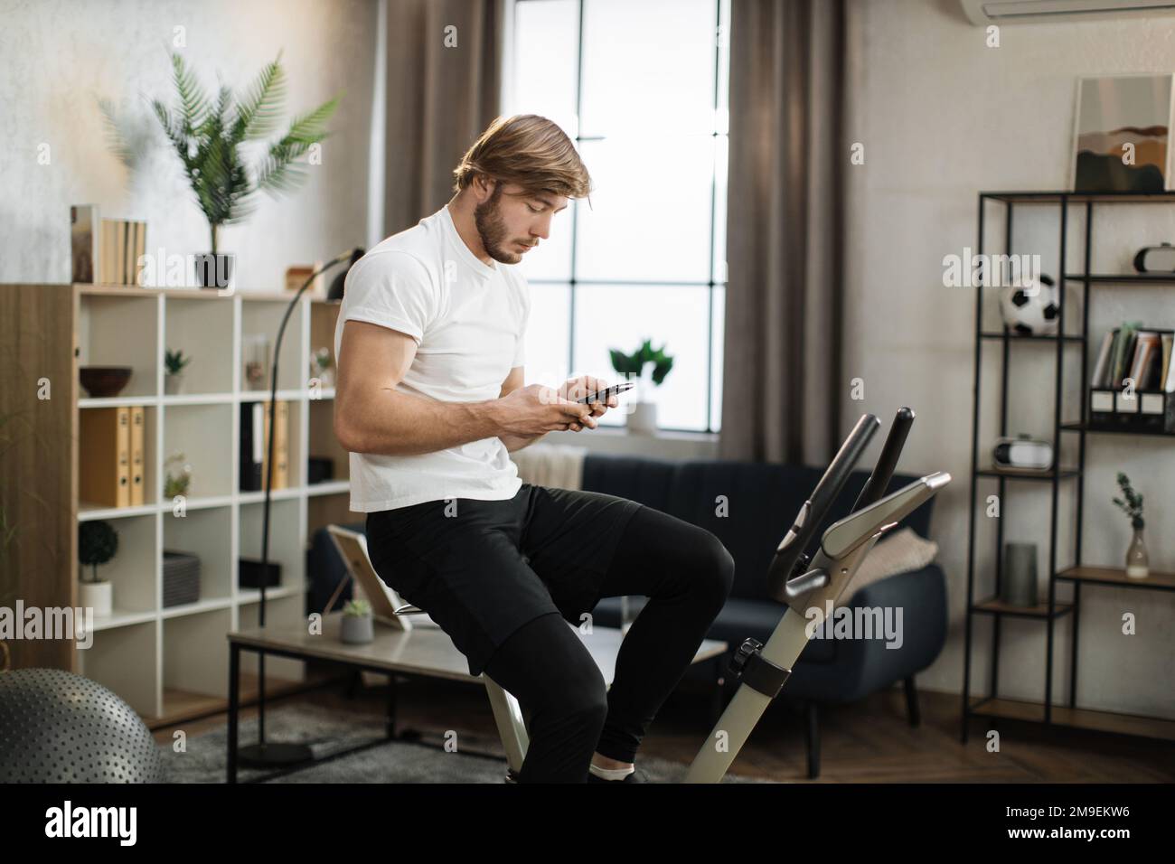 Healthy fit smiling caucasian man training at home on exercise static ...
