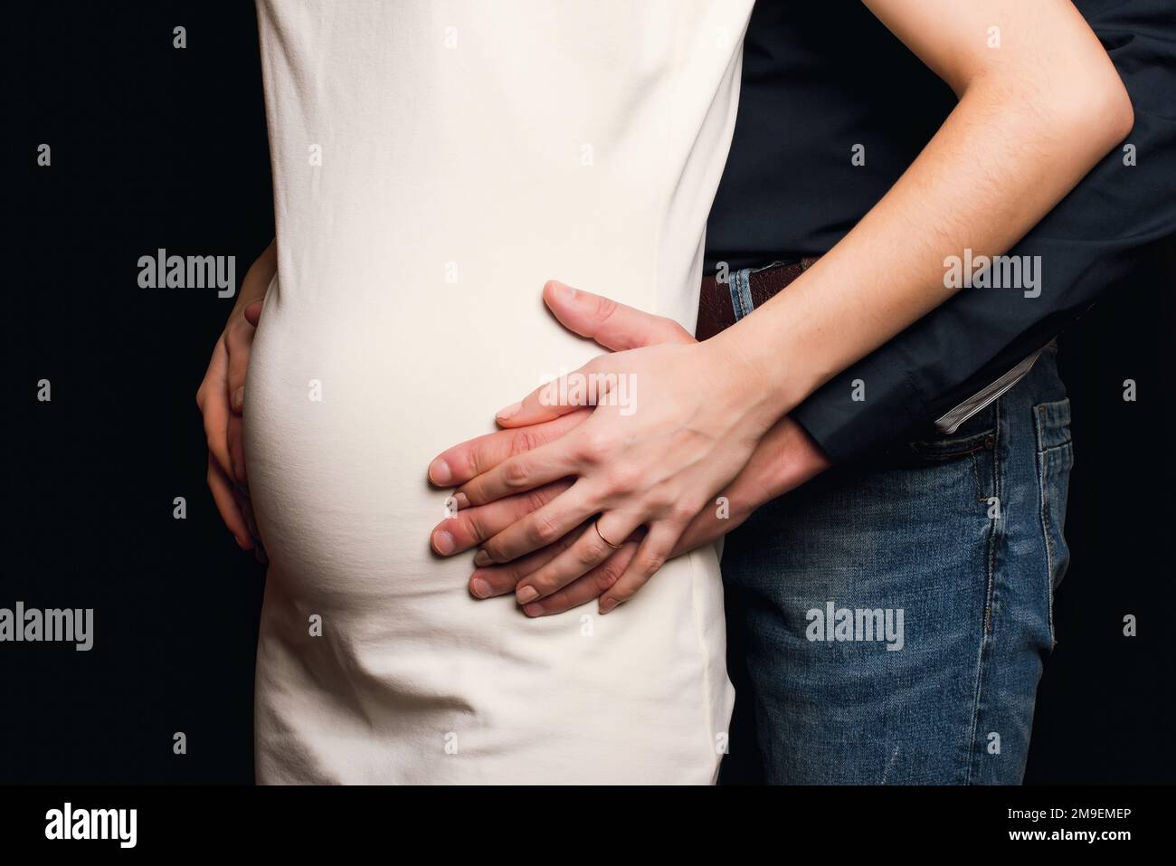 man hugs the belly of a pregnant girl. Couple is expecting a baby ...
