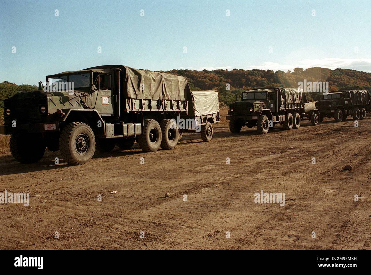 Left side front view of a US Marine convoy of M923A1 (6X6) 5-ton cargo ...