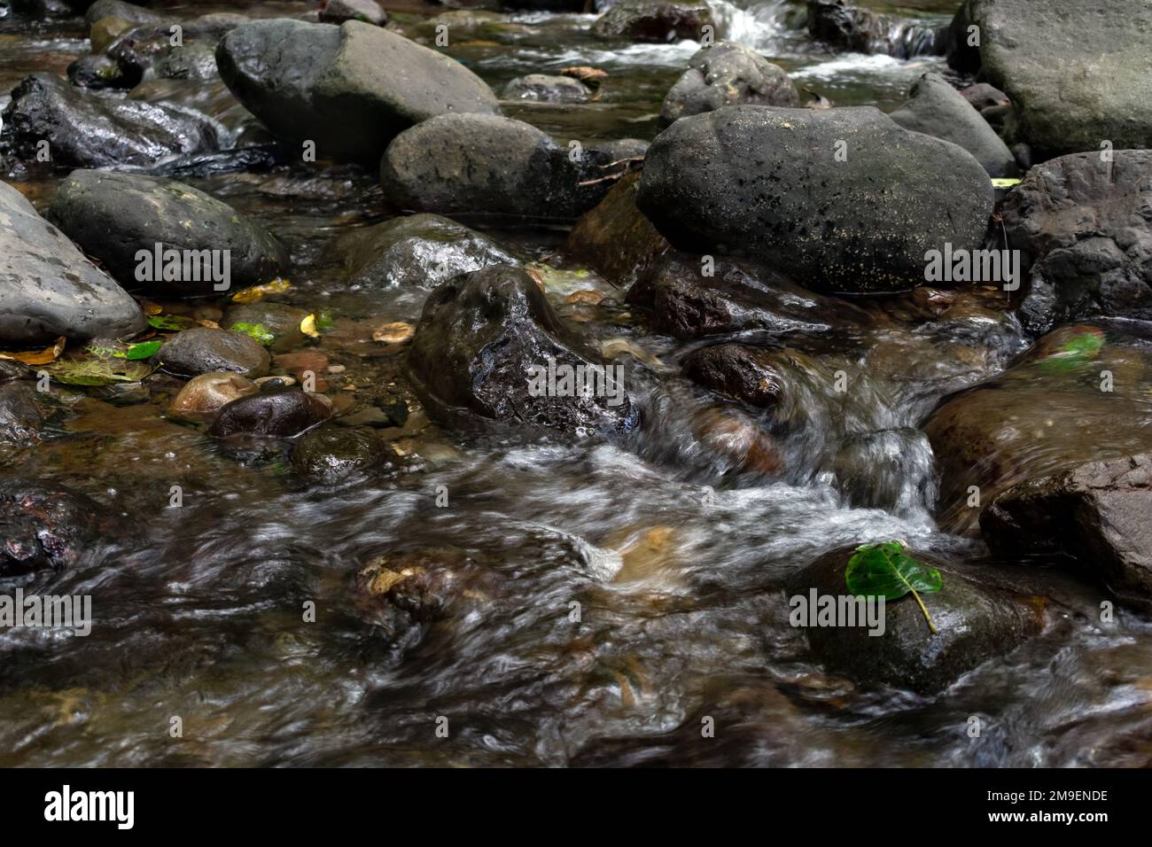Water over river stones Stock Photo - Alamy