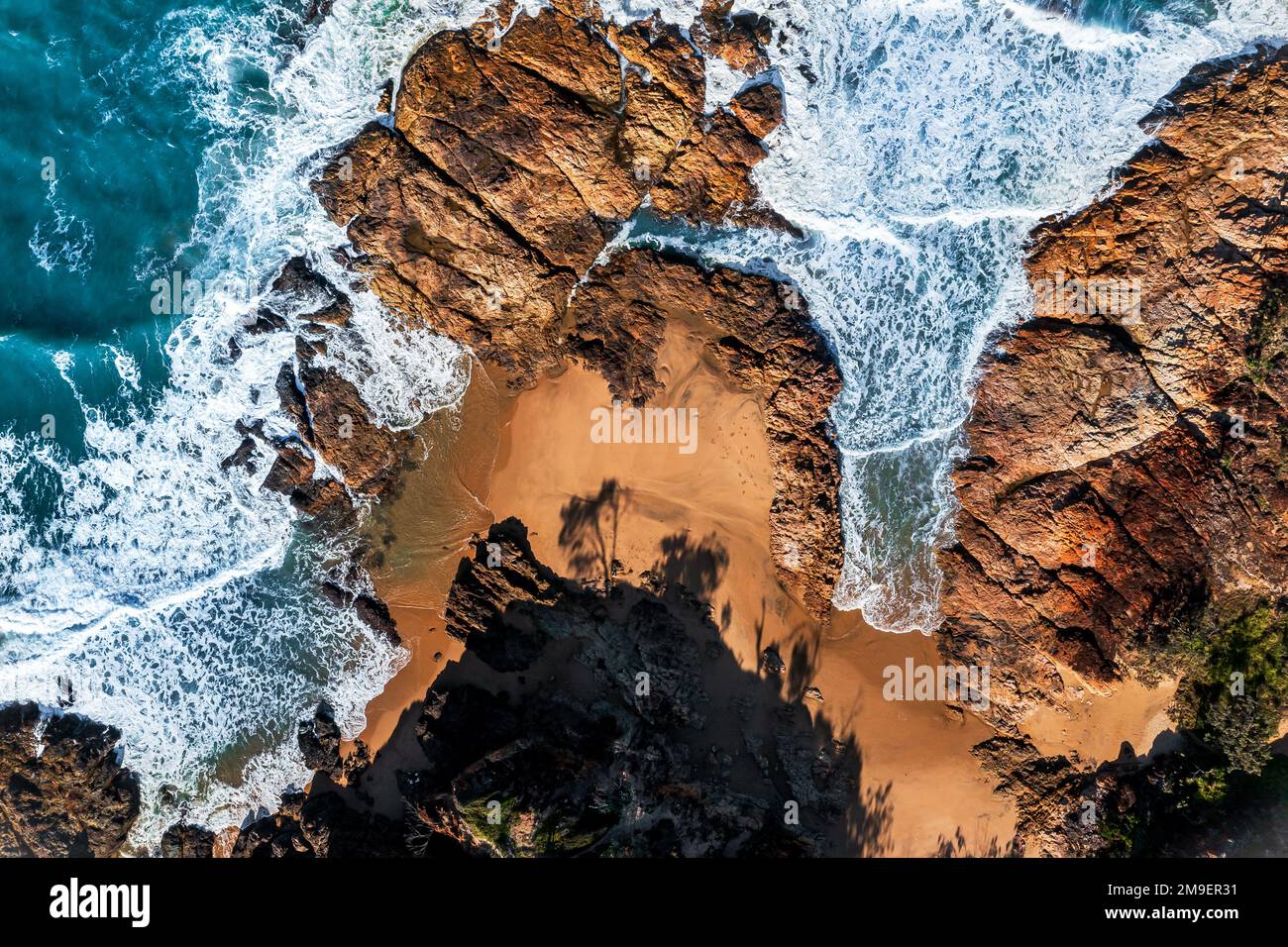 Aerial view of sea waves and sandy beach with rocks, Seventeen Seventy ...