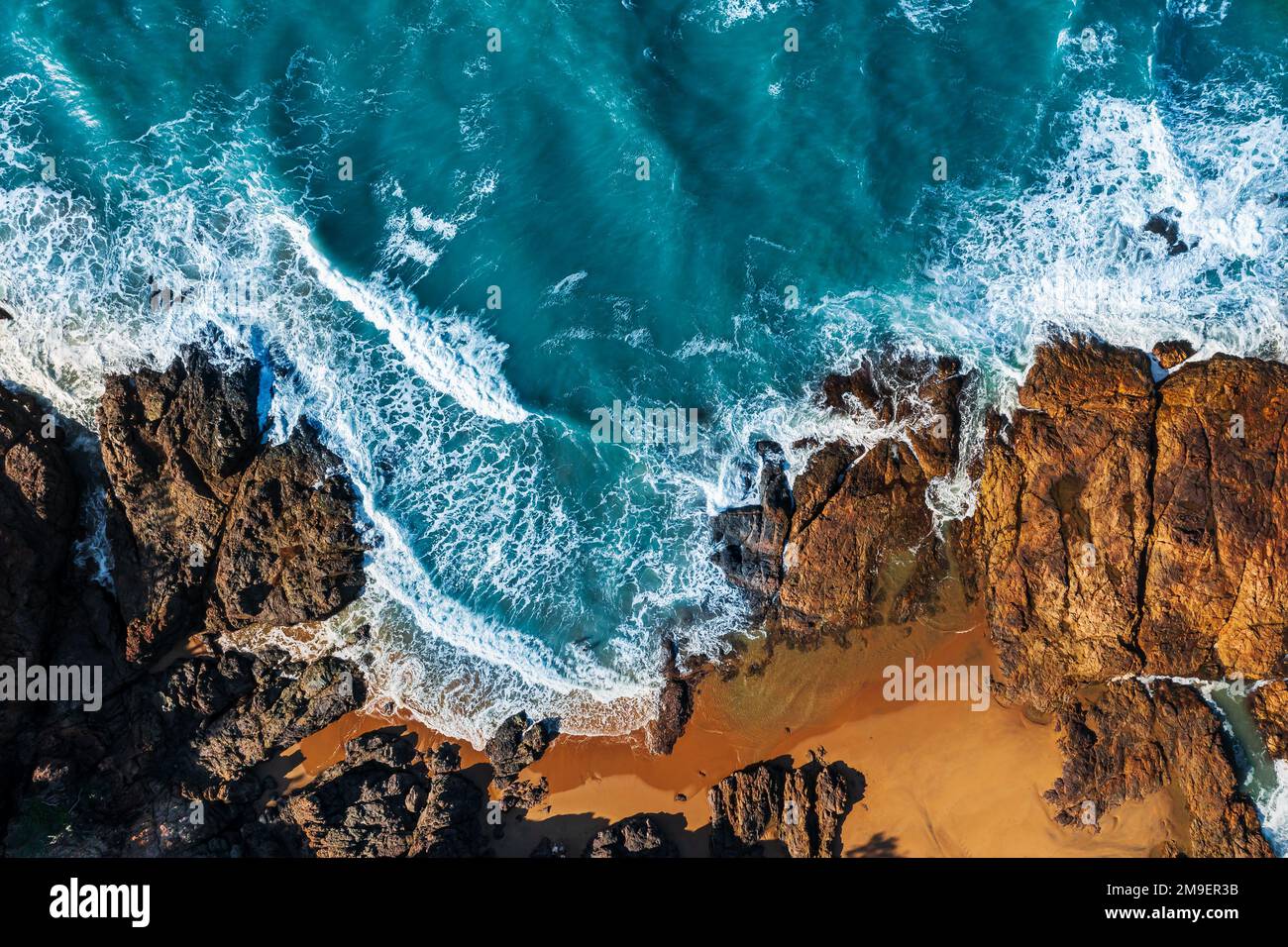 Aerial view of sea waves and sandy beach with rocks, Seventeen Seventy ...