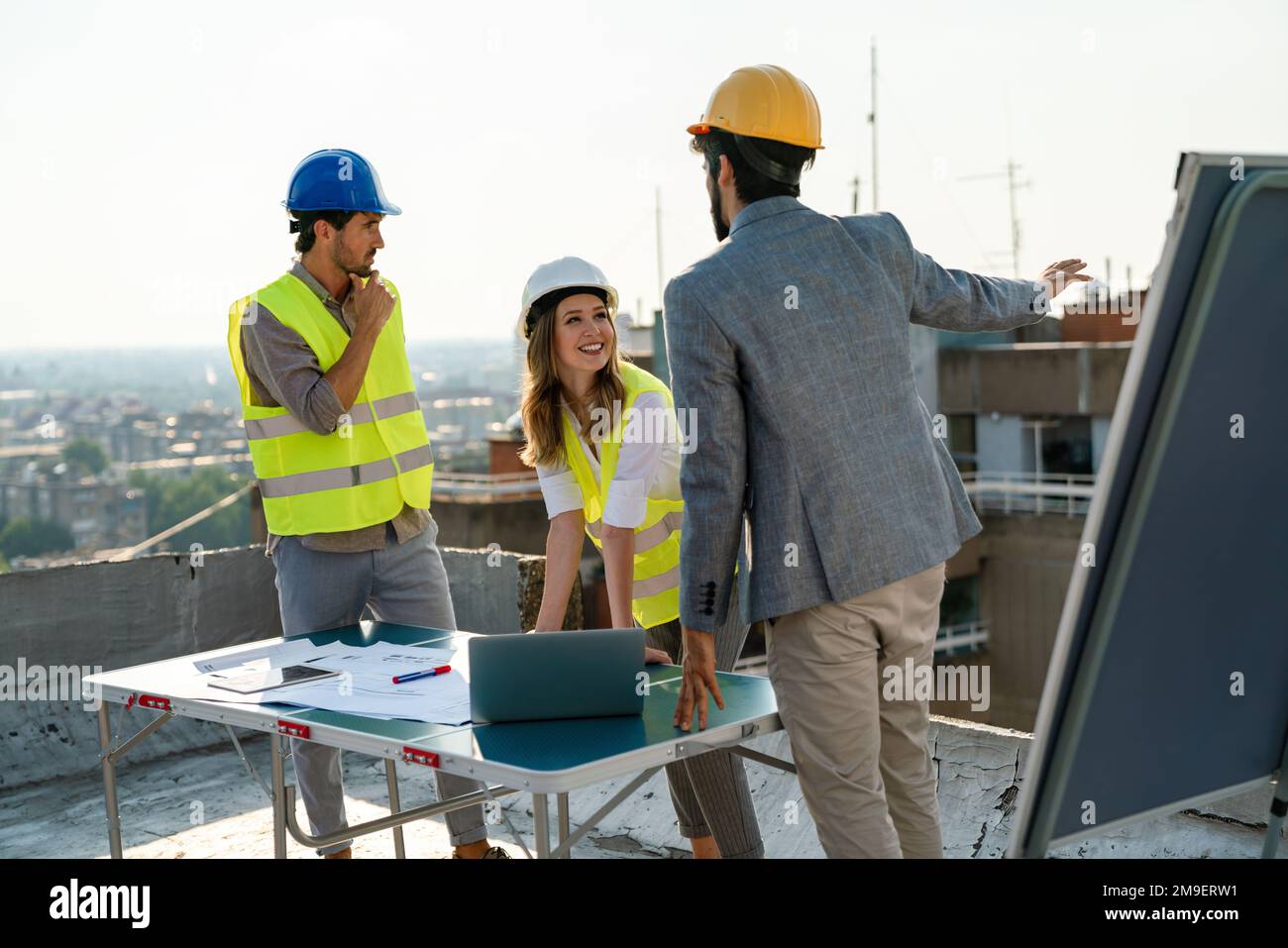 Diverse team of specialists with computer on construction site ...