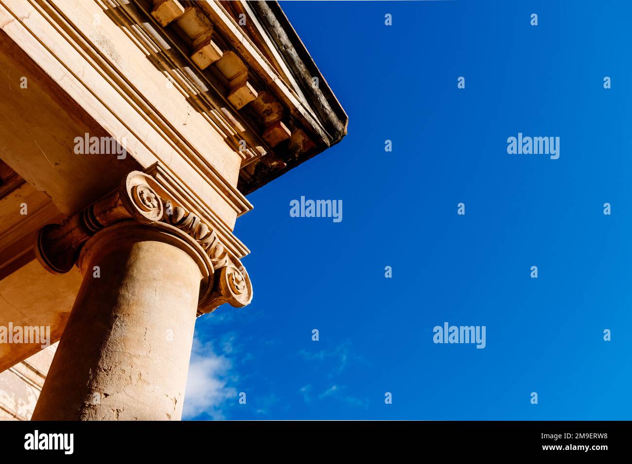 A portico with columns and a triangular pediment on the Greek-style facade of a temple Stock ...