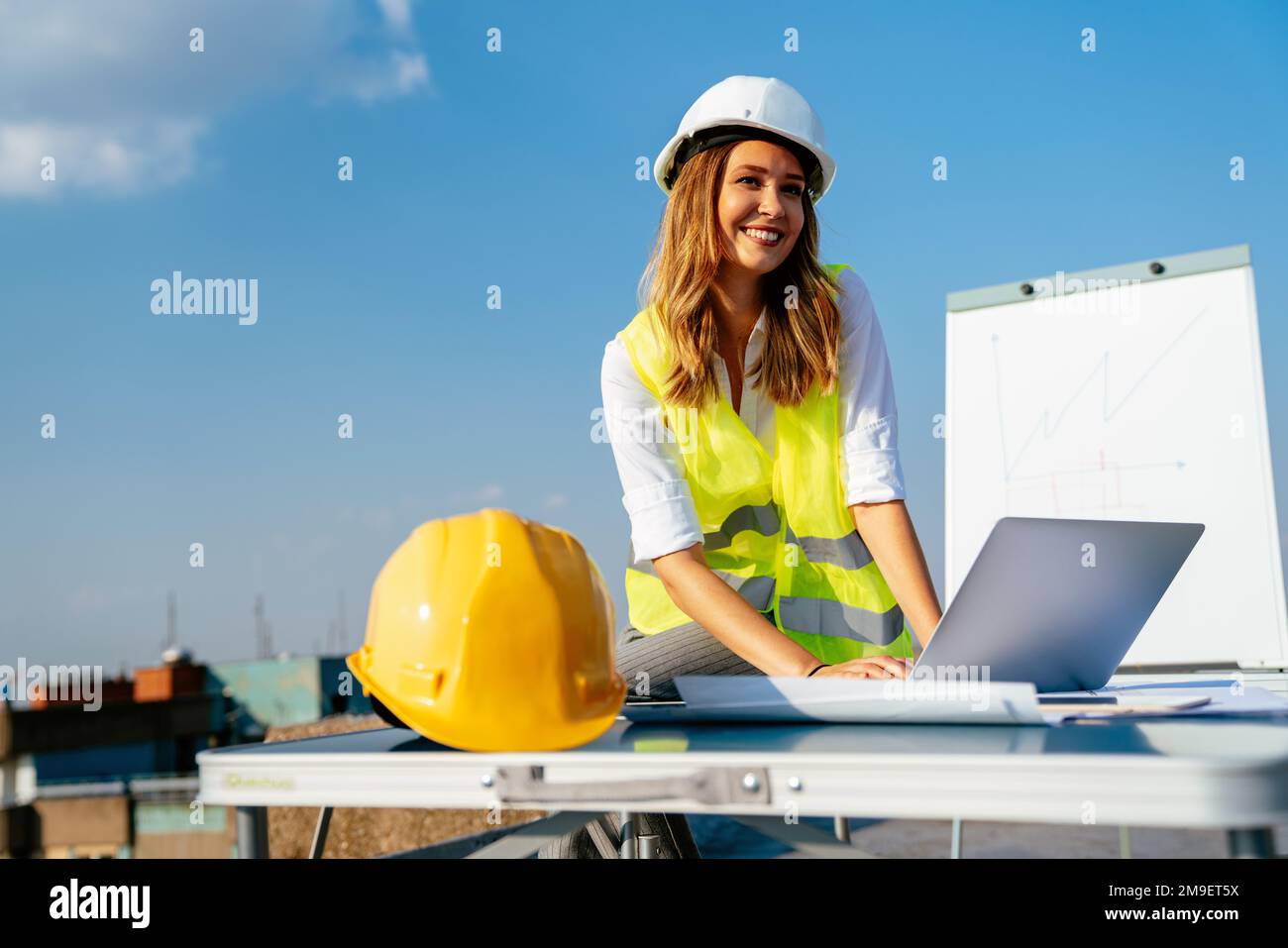 Young female construction specialist engineer reviewing blueprints at ...