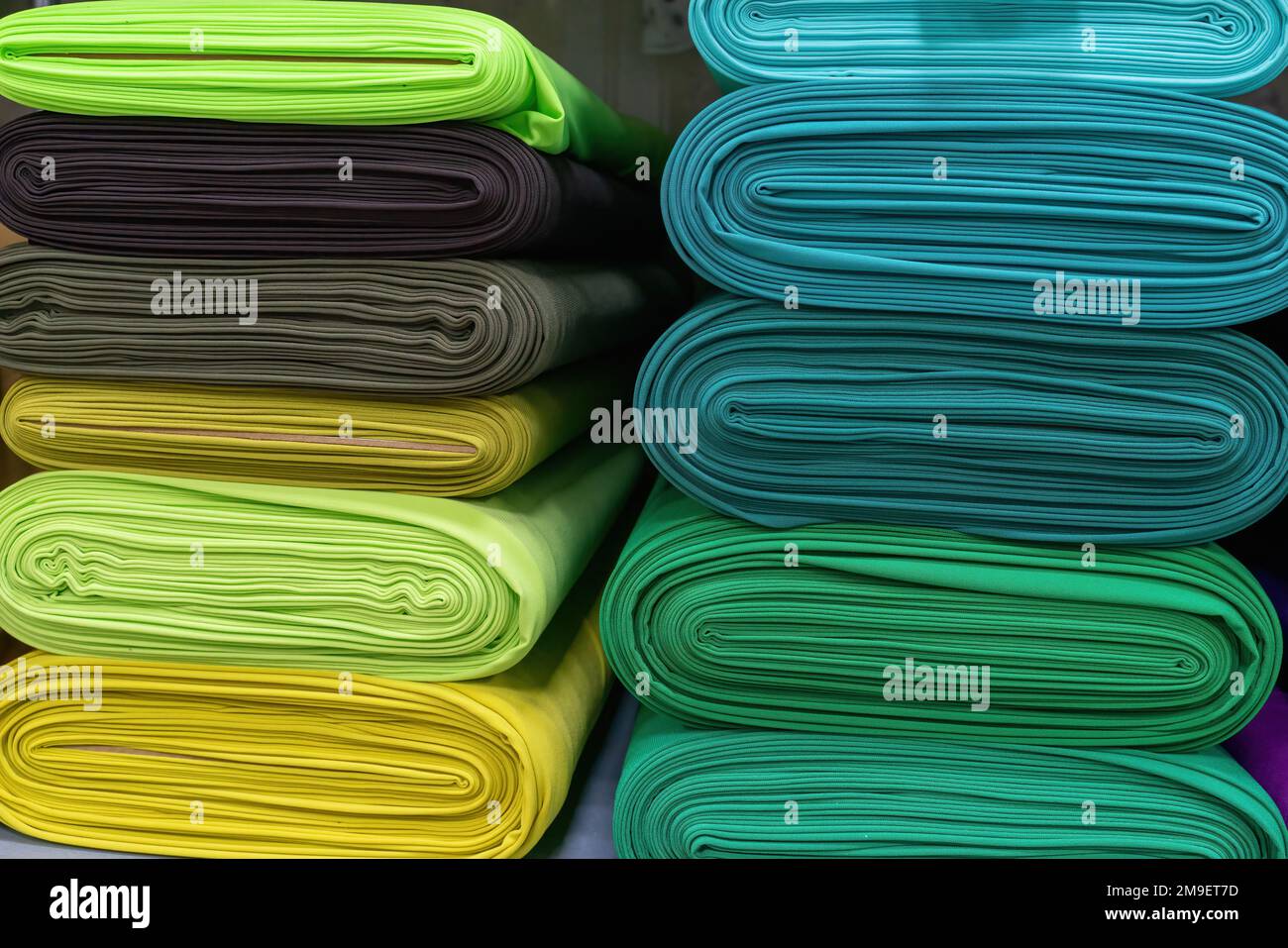 Layers of colorful fabric, colorful background. Pile of bright rolls of ...