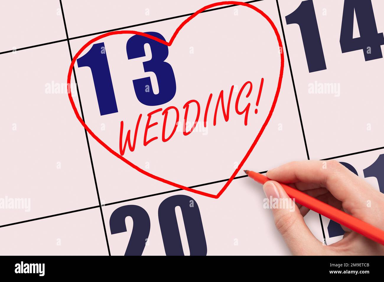 13th day of the month. Hand writing text WEDDING and drawing a red ...