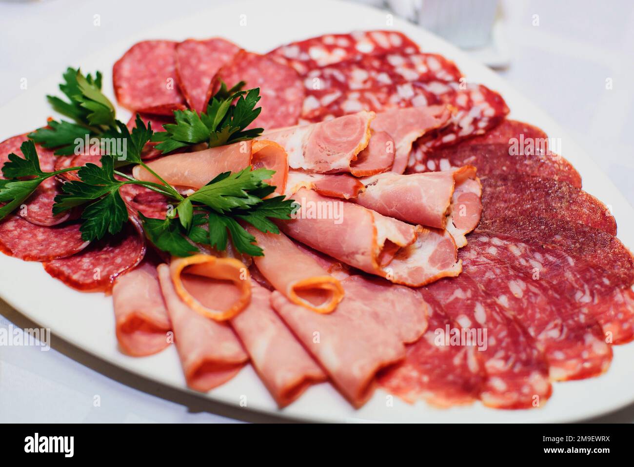 slices of ham and sausage on a plate for a snack in the restaurant ...