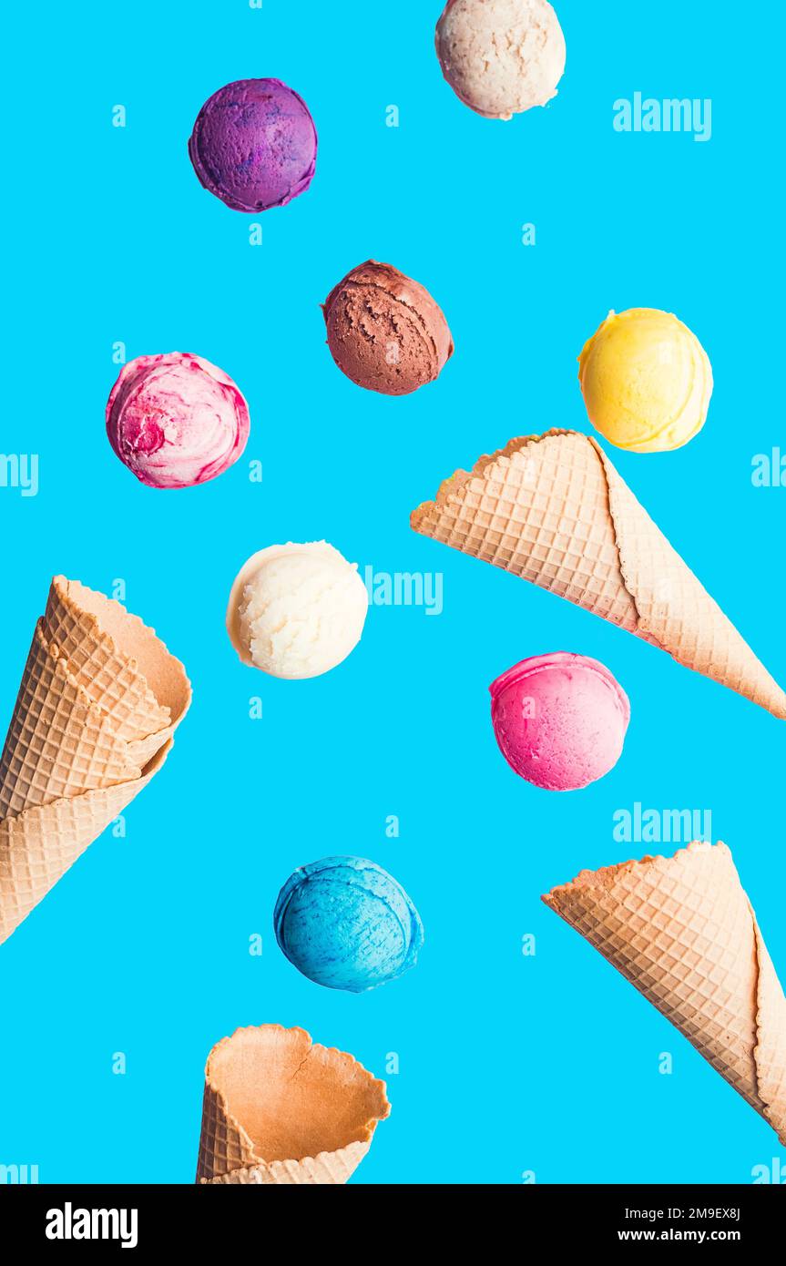 Falling ice cream scoops into the vafel cone on blue background. Food ...