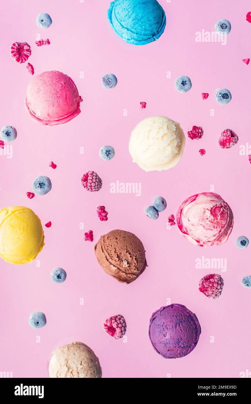 Falling ice cream scoops and berries on pink background. Food ...