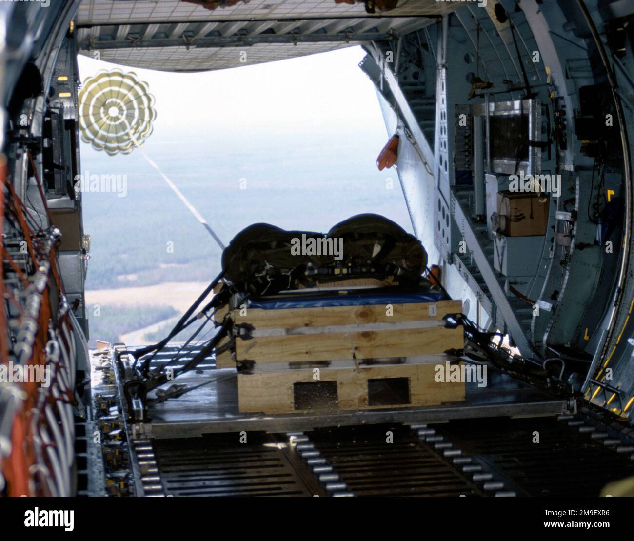 A palletized heavy load is dropped out the back of a C-141B Starlifter ...