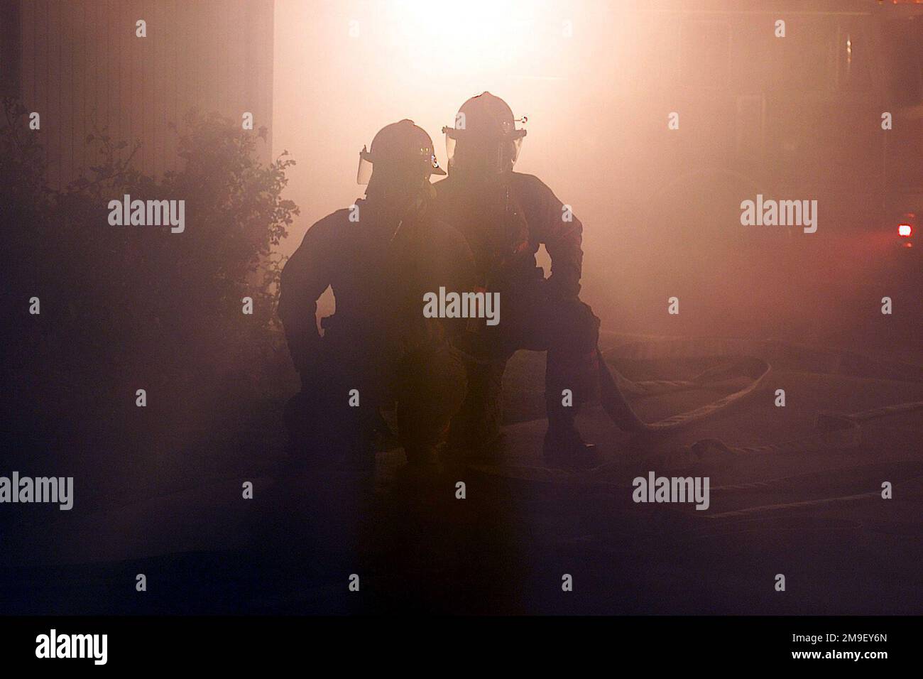 Straight on view, medium nighttime shot as US Air Force firemen respond ...