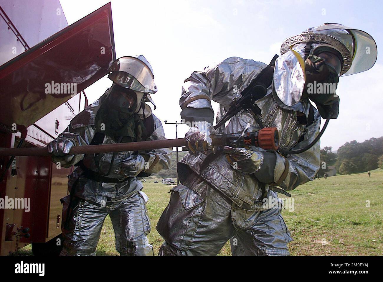 Straight on medium close up as US Air Force Firemen respond to an ...