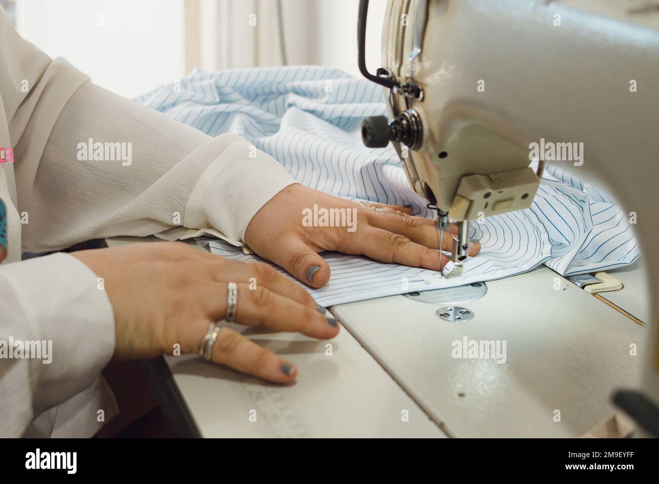 closeup detail of unrecognizable caucasian young woman, sewing cotton ...