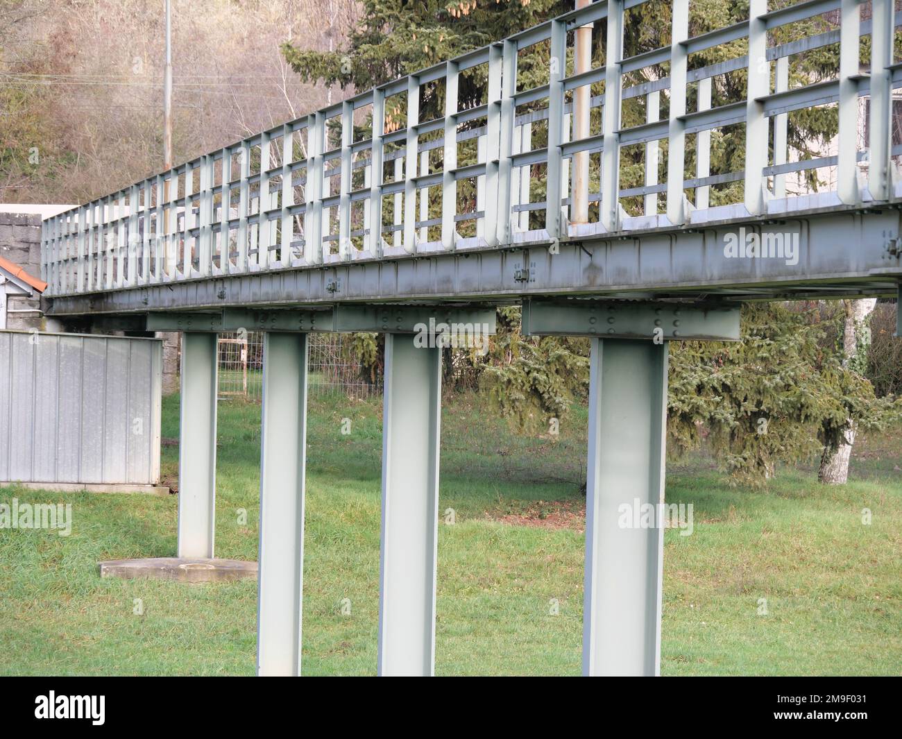 Perspective view of a pedestrian bridge with steel railing and grating ...