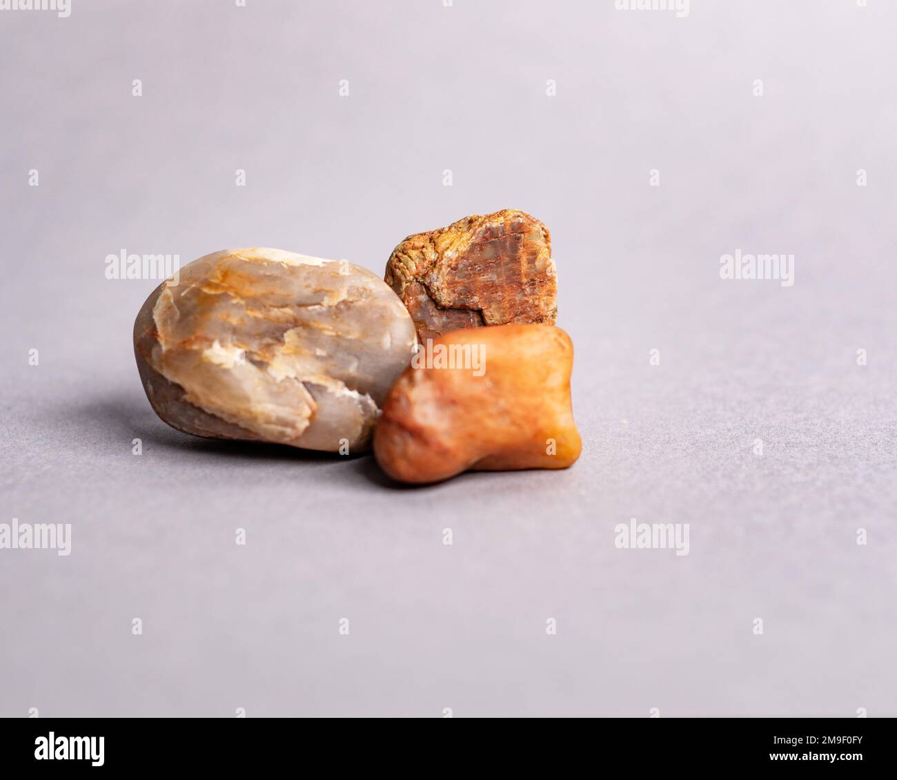 A close-up of the natural stones placed by each other, on a light ...