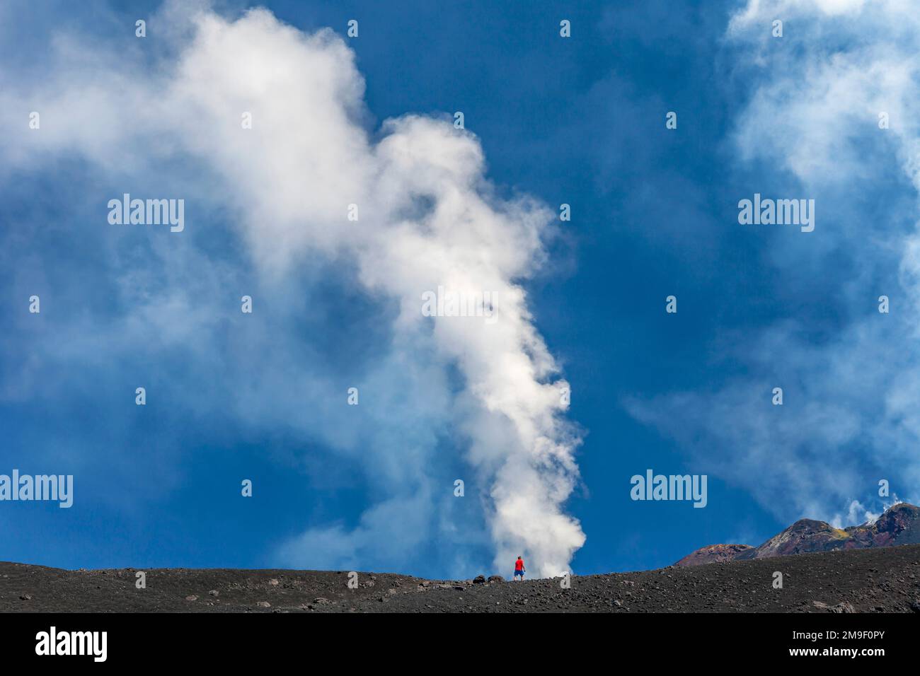 Lone figure walking past active volcanic steam vents on Mount Etna ...