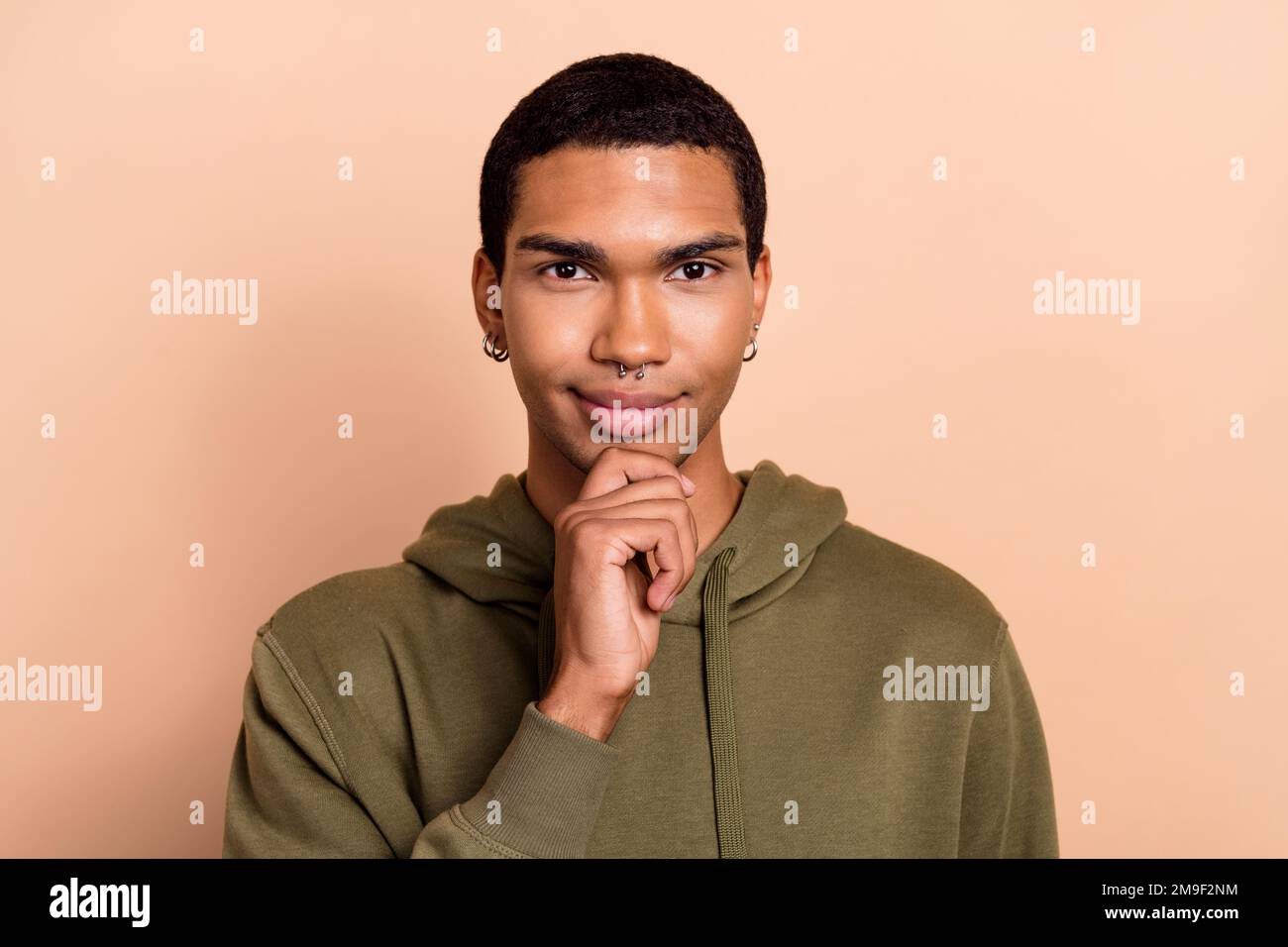 Photo of young confident serious guy smiling touch chin wear khaki ...