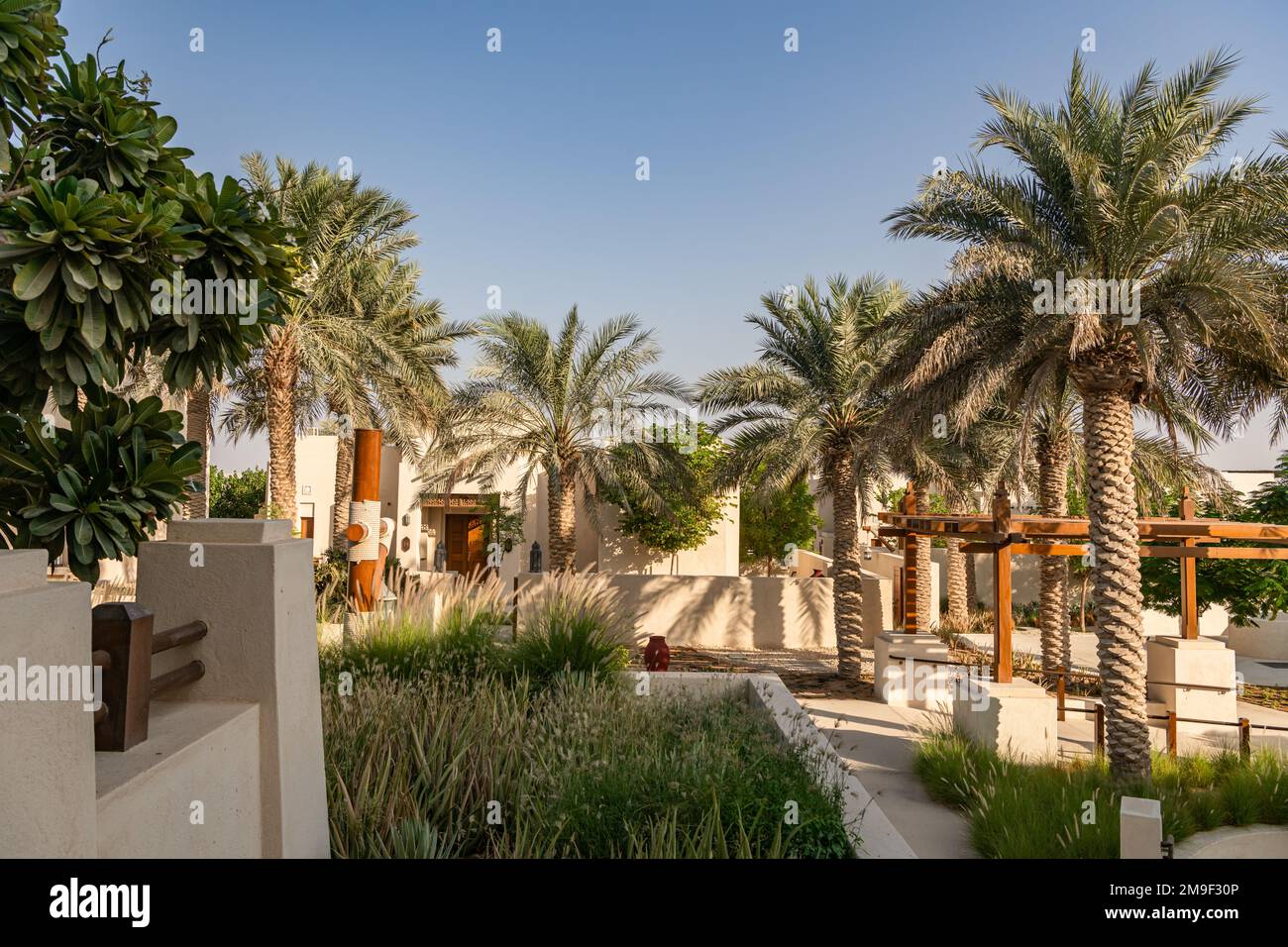 The lush gardens with palm trees and sand coloured buildingsat the ...