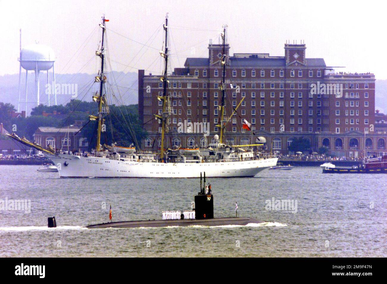 The attack submarine USS Hampton (SSN 767) steams by a Tall ship ...
