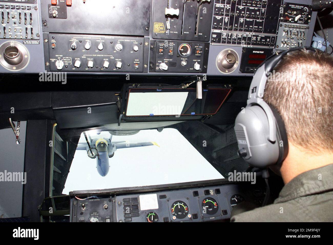 Rear view medium shot over the shoulder of KC-10 Extender Boom Operator ...