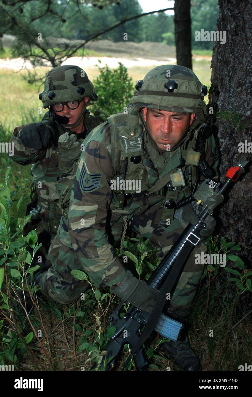 Straight on medium shot of two USAF Sergeants as they crouch down near ...