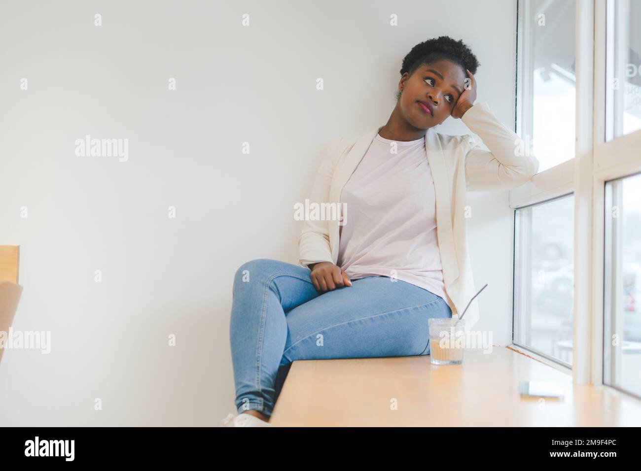 Relaxed african woman drinking morning coffee at cafe, sitting near ...