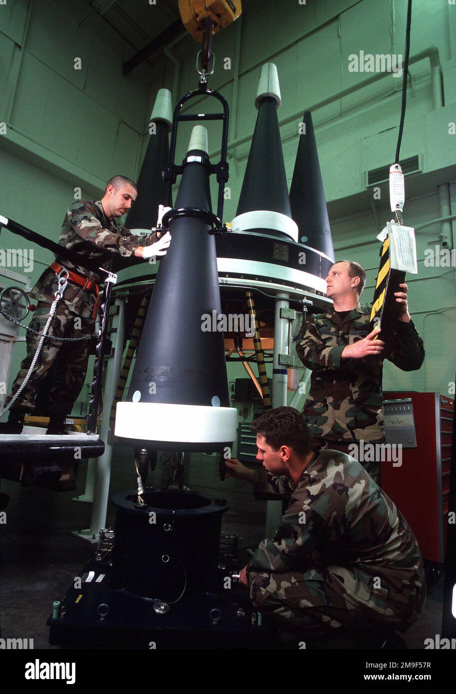 US Air Force maintenance crews use a overhead crane and hoist to remove ...
