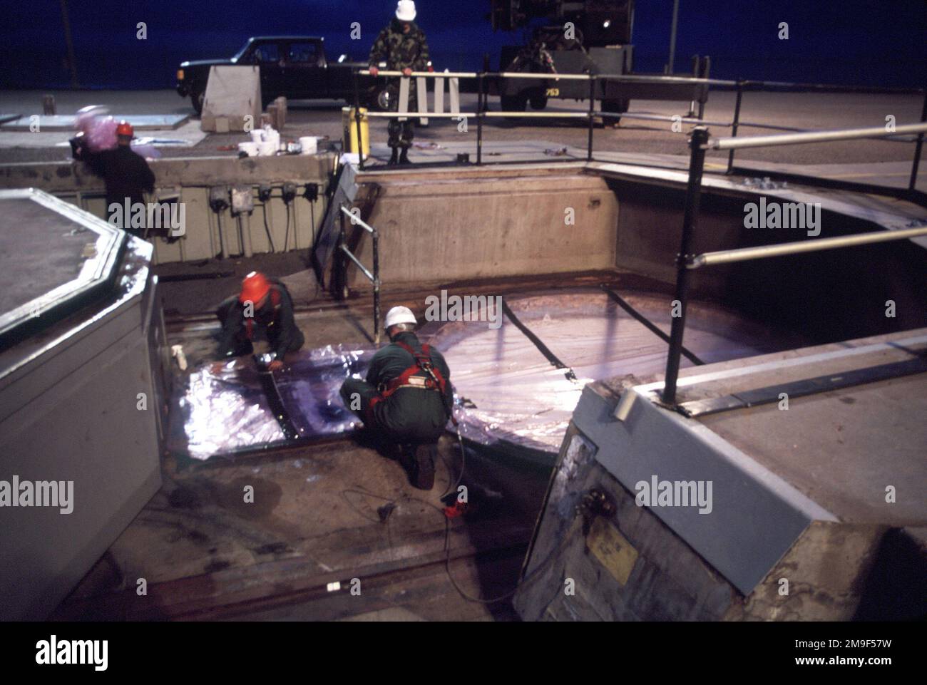 US Air Force maintenance crews cover the exposed silo hole of a ...