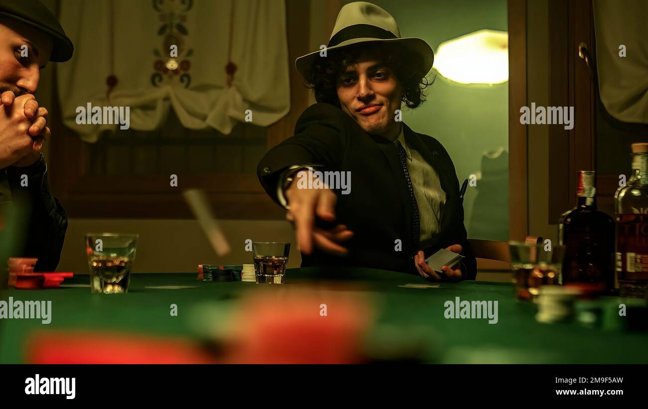 A group of mobsters gather around a table in a dimly lit nightclub. One ...