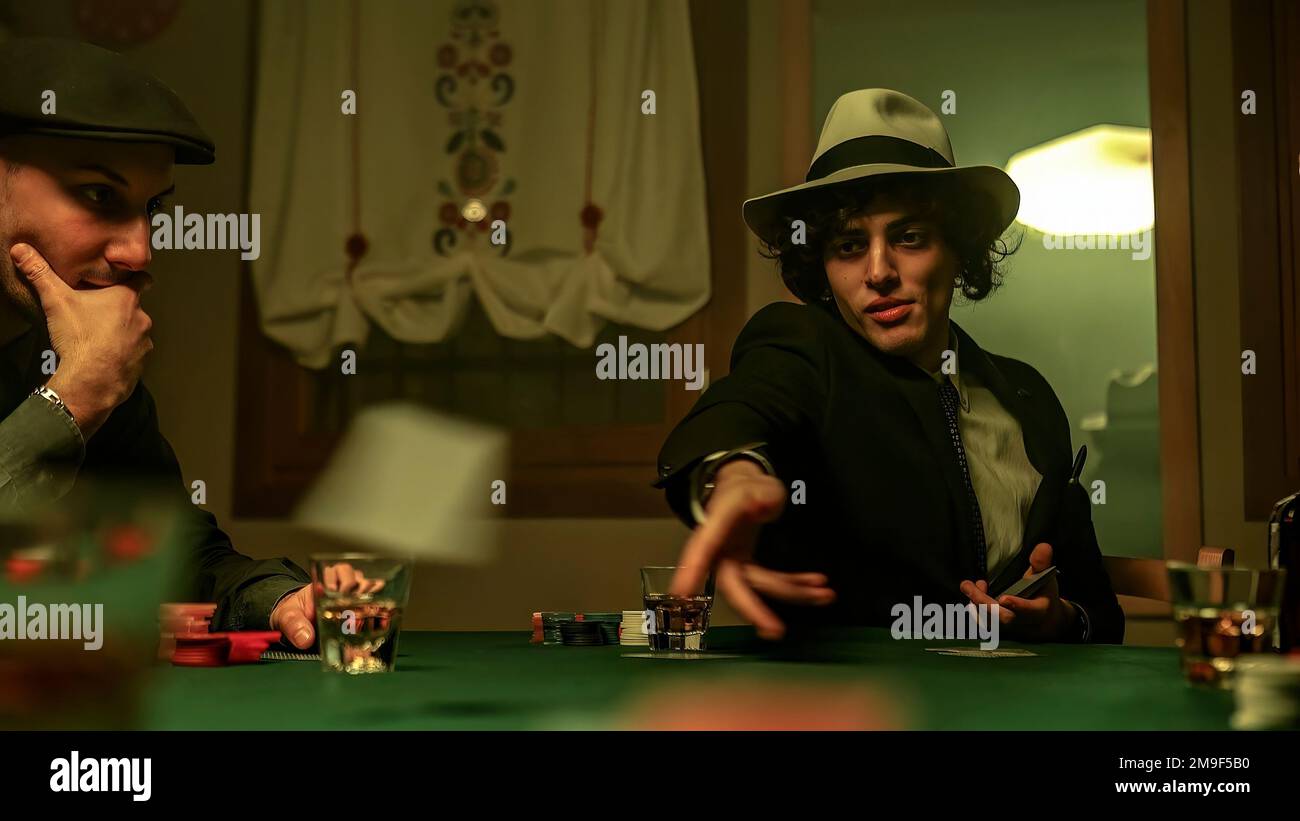 A group of mobsters gather around a table in a dimly lit nightclub. One ...