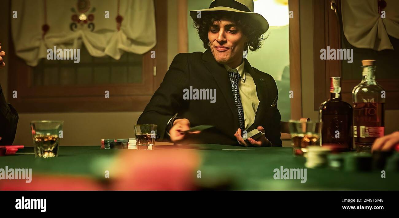 A group of mobsters gather around a table in a dimly lit nightclub. One ...