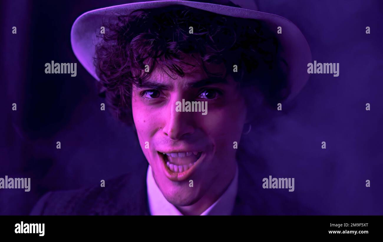 A young man with dark brown hair is happily singing and dancing with ...