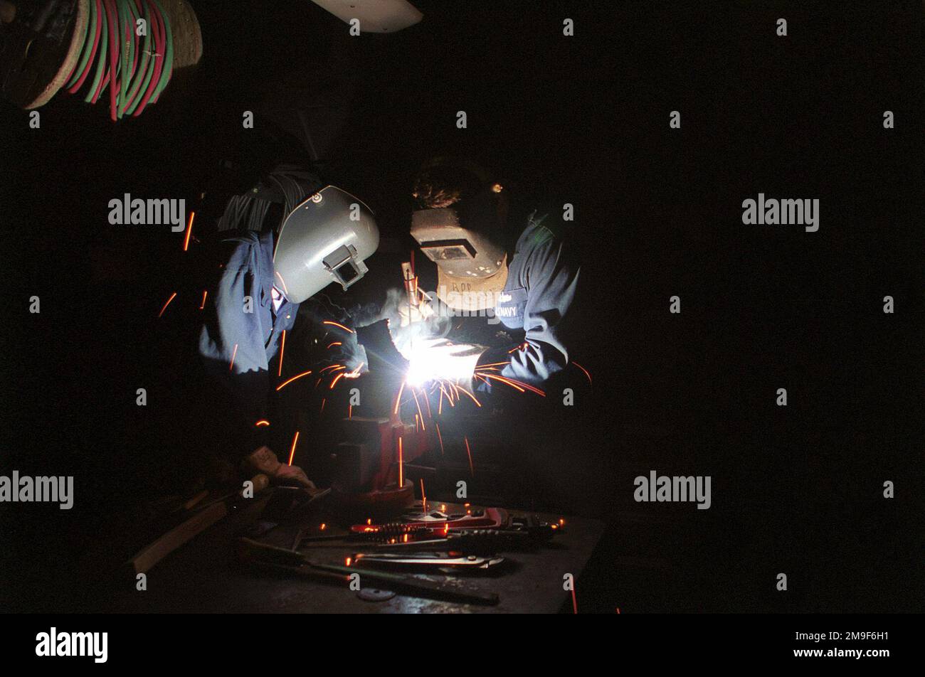 Hull TechicianS weld a piece of equipment in the pipe shop on board USS ...