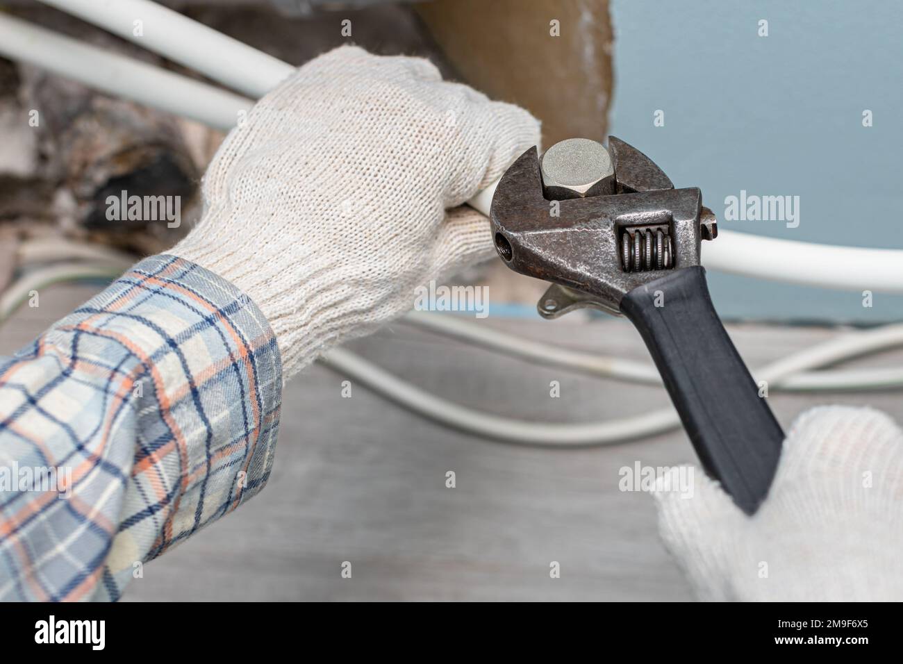 man repairing a pipe with a pipe wrench. plumber repairing a pipe. man ...