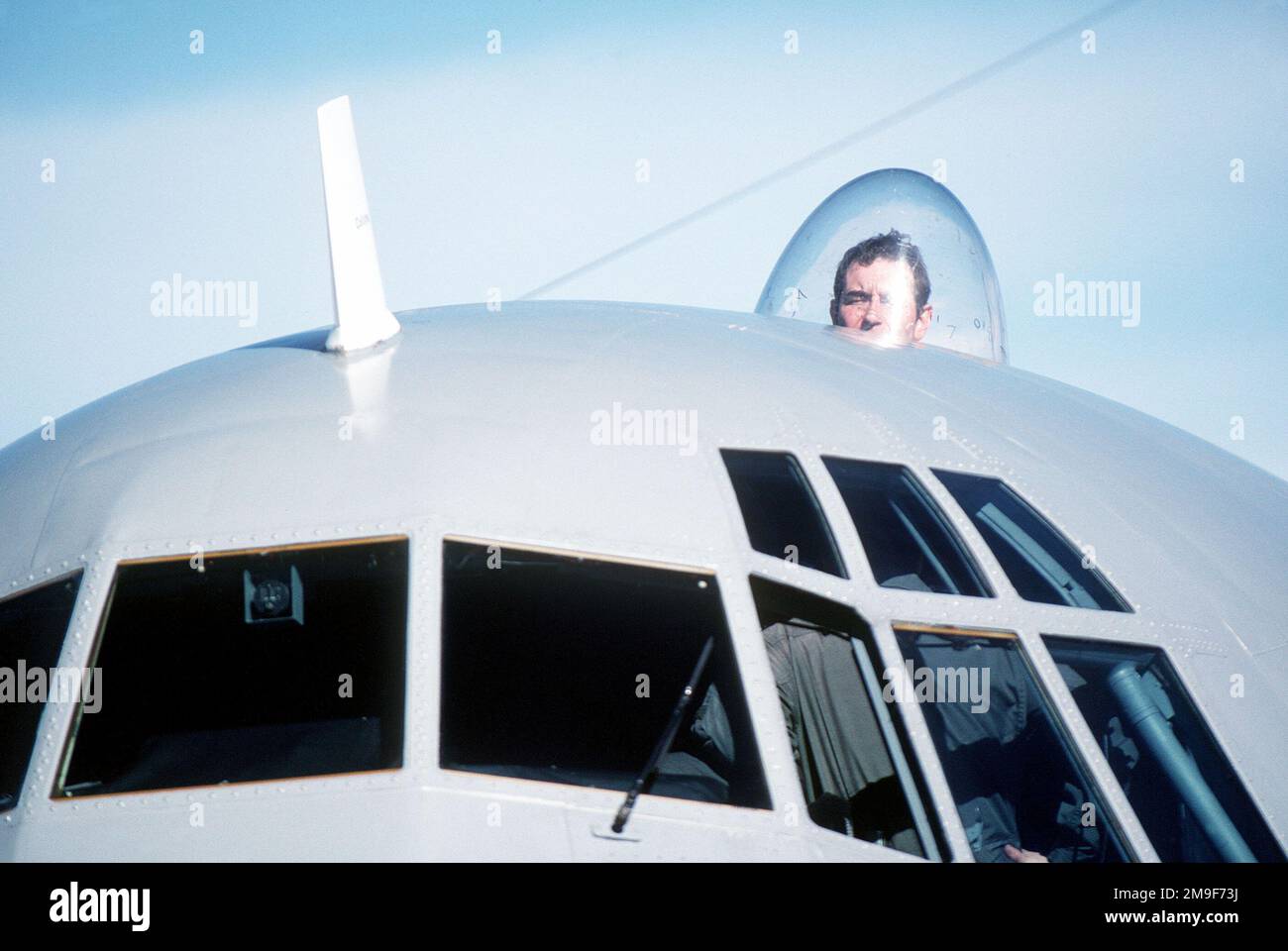 A US Air Force C-130 Hercules aircraft crewmember looks out the bubble ...