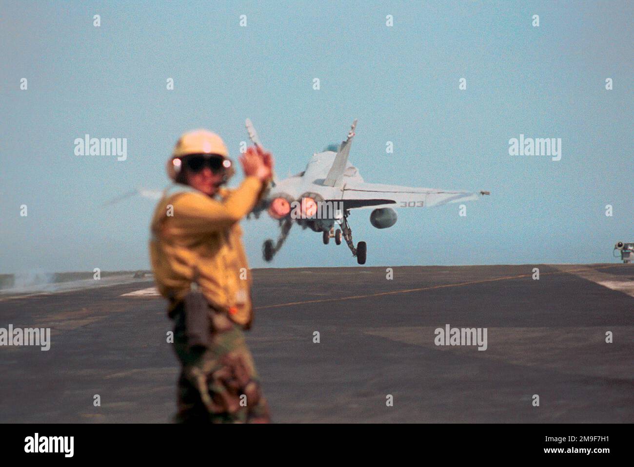 Aviation Boatswains Mate (Handler) 1ST Class Larry Tarver signals to ...