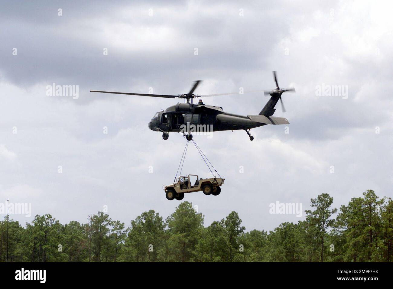 A UH-60 Blackhawk helicopter slings a High-Mobility Multipurpose Wheeled Vehicle (HMMWV) during ...