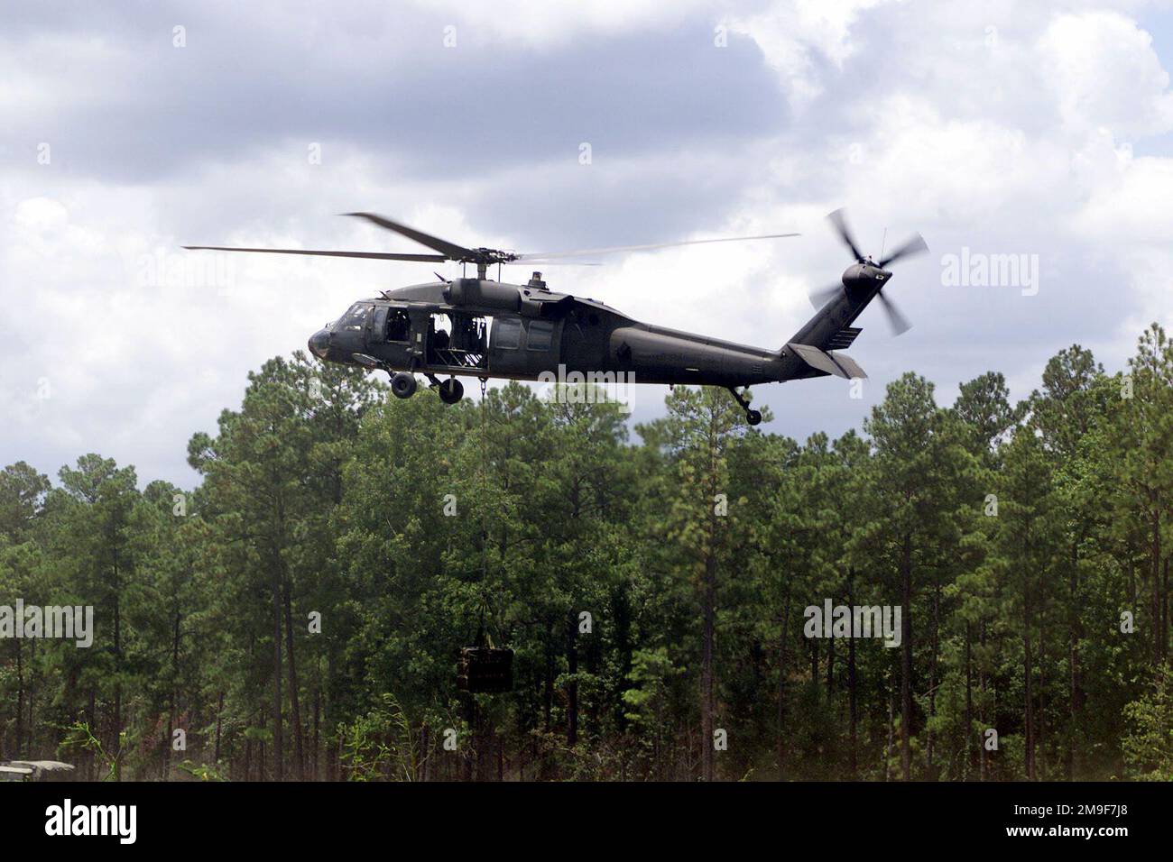 A UH-60 Blackhawk helicopter prepares to drop a resupply bundle during ...