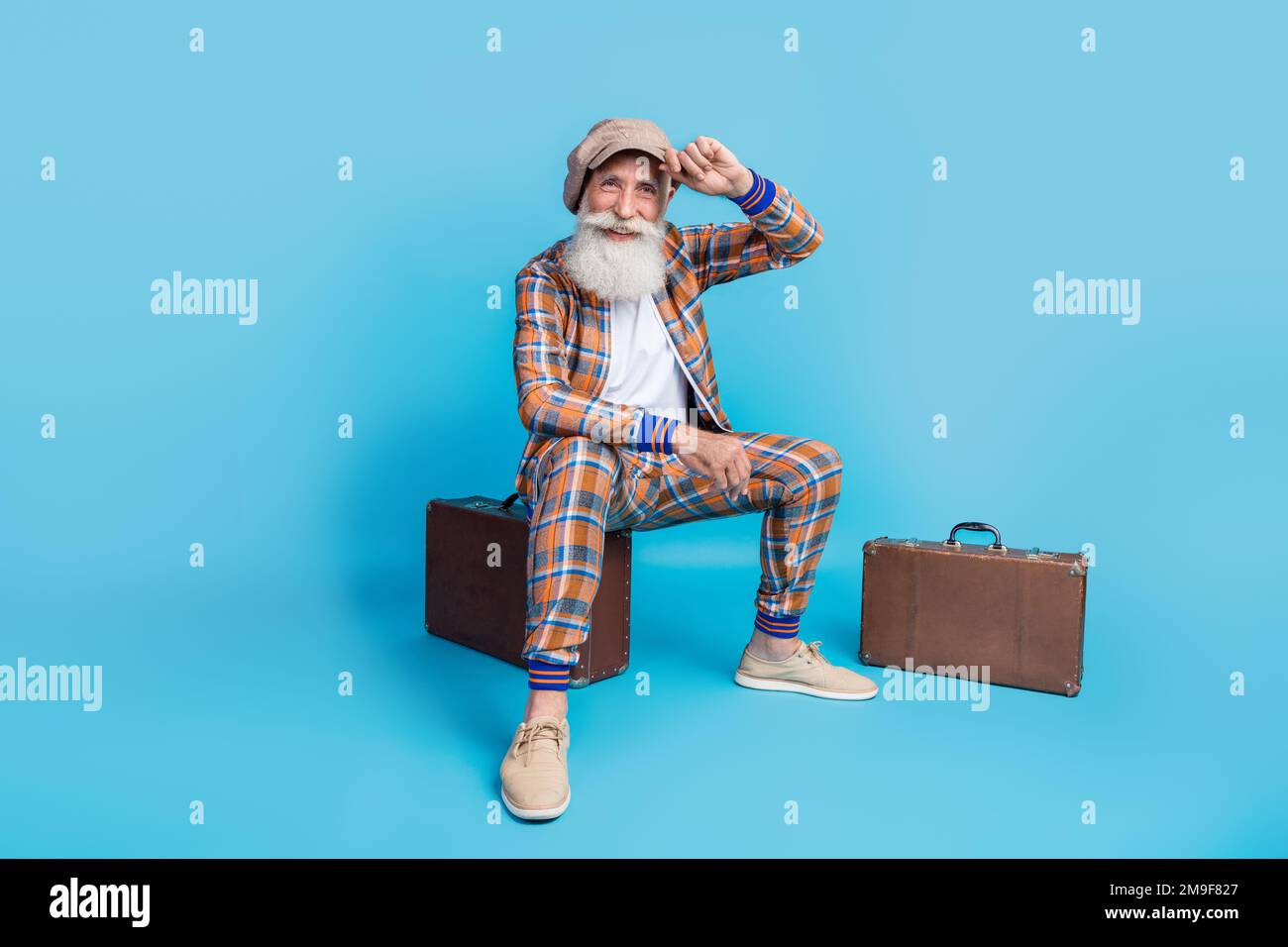 Full length photo of cheerful grandfather sitting bag hand touch ...