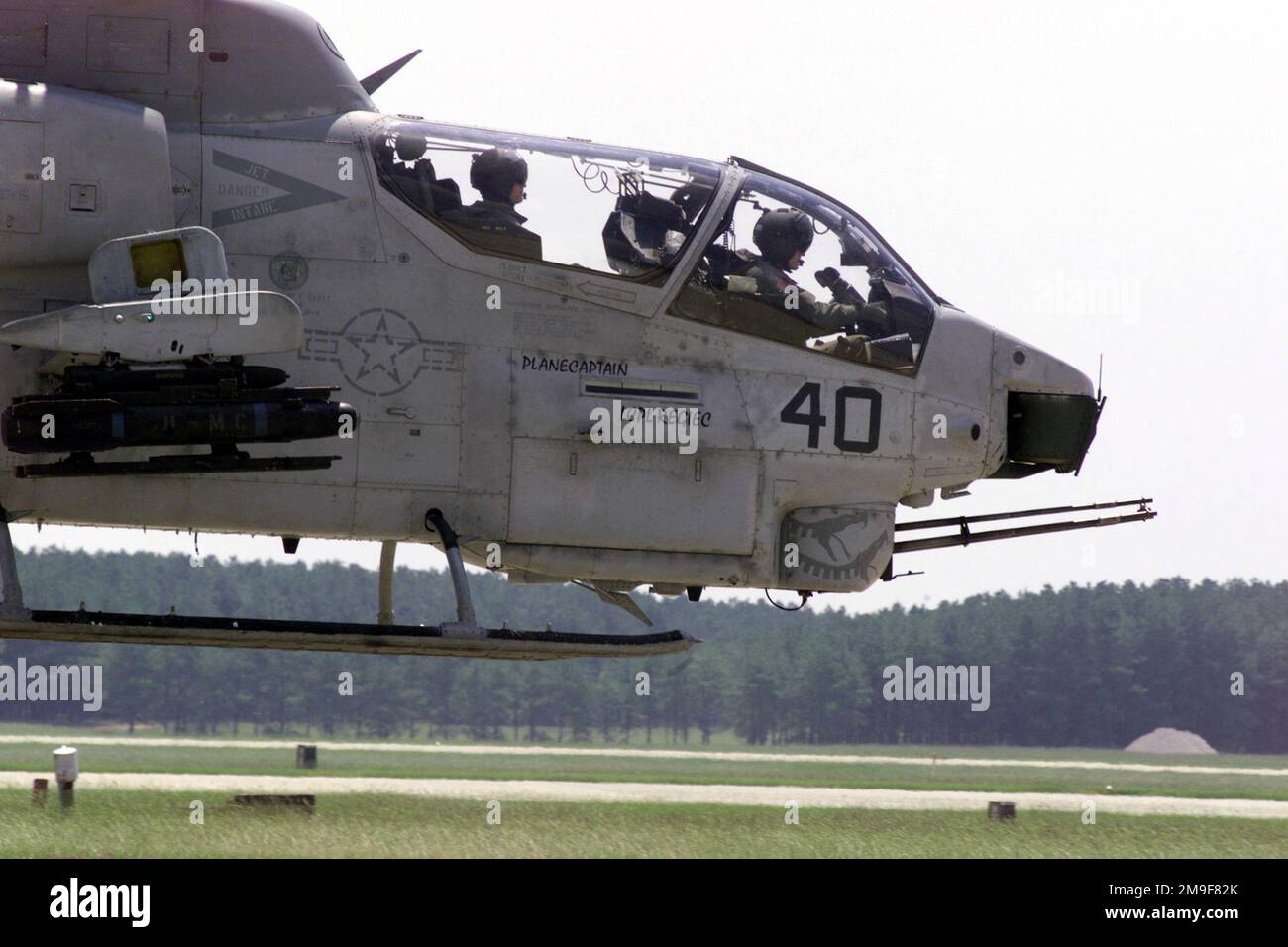 A United States Marine Corps AH-1W Super Cobra attack helicopter hovers ...