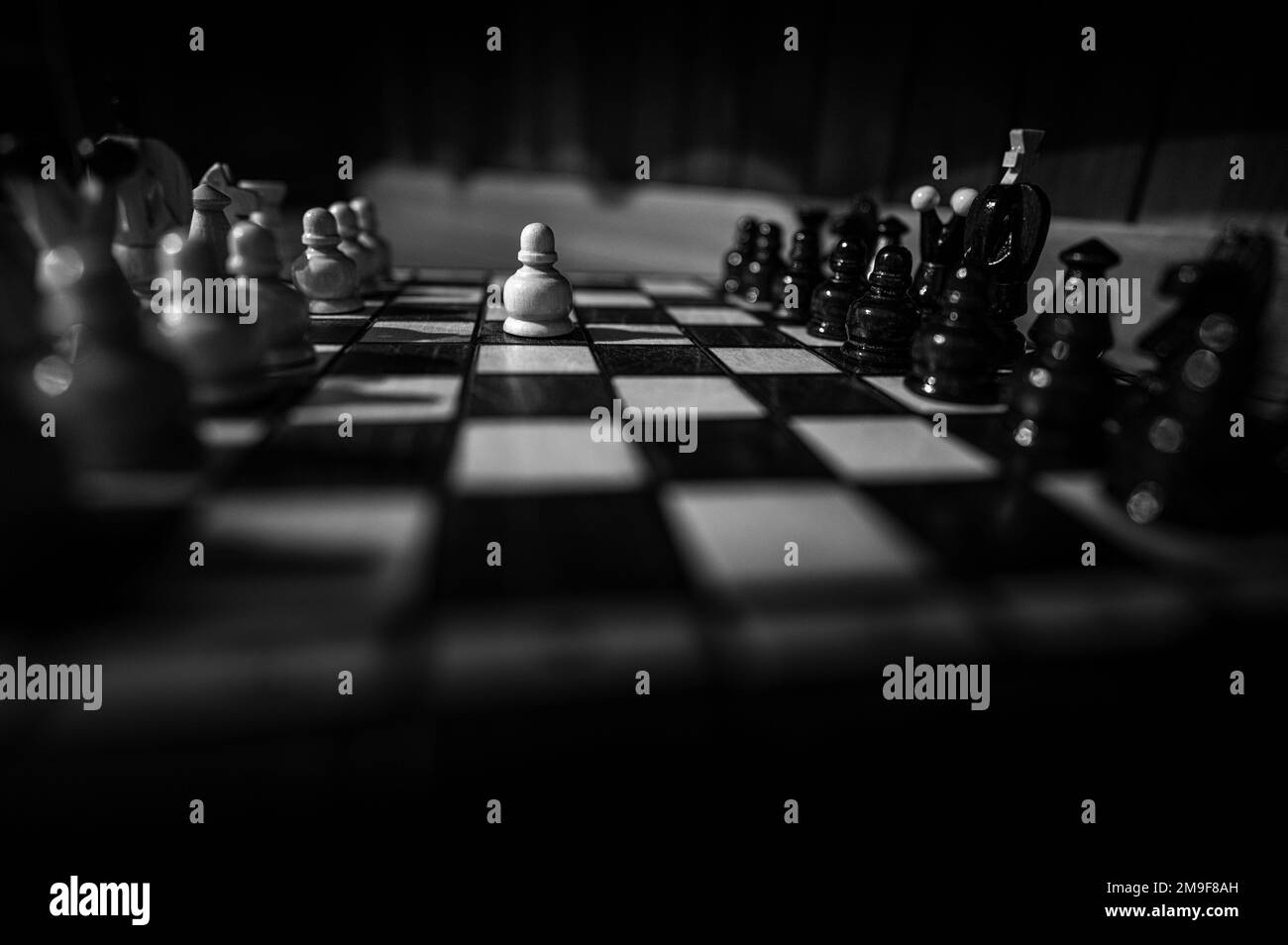 The set of wooden chess pieces elements standing on chess board on dark ...