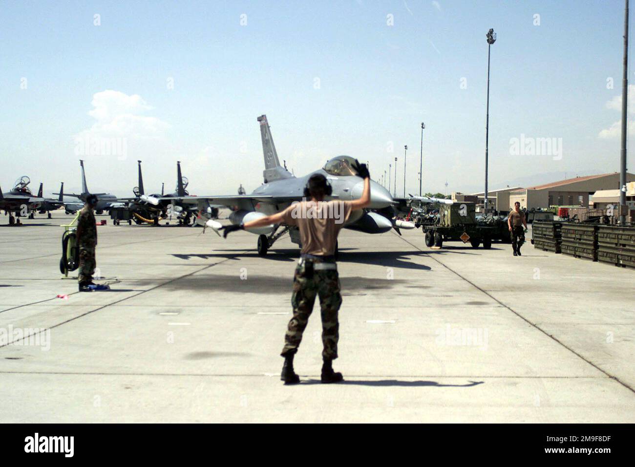 Crew chief AIRMAN First Class Sean Keane directs an F-16 Fighting ...